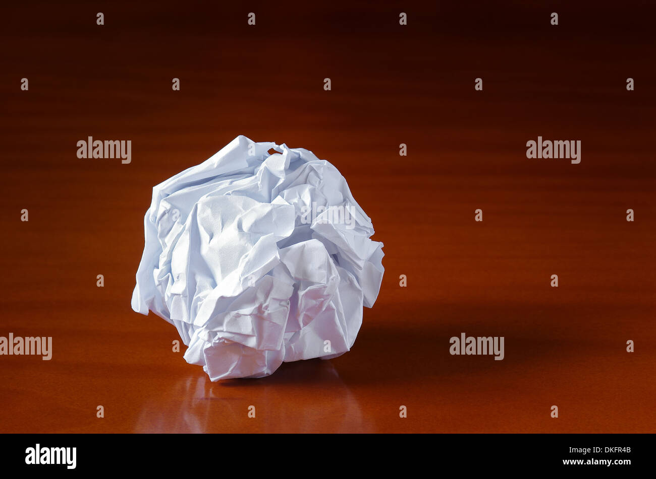 Ball of smashed sheet of paper over wooden table Stock Photo - Alamy