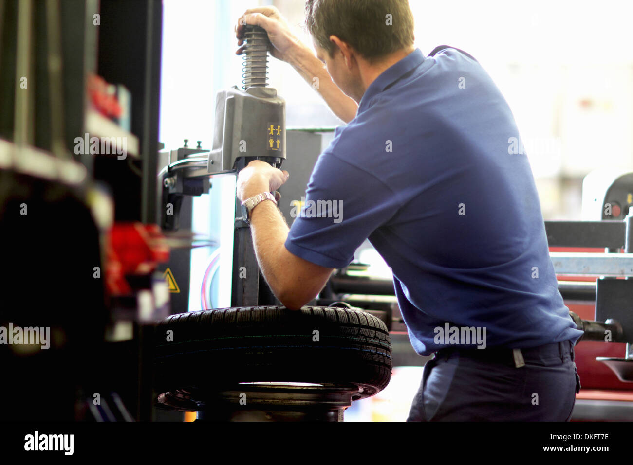 Mechanic repairing wheel in workshop Stock Photo - Alamy