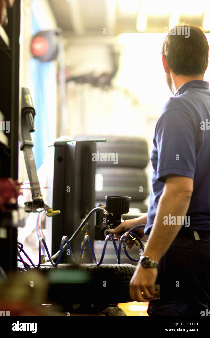 Mechanic repairing wheel in workshop Stock Photo - Alamy