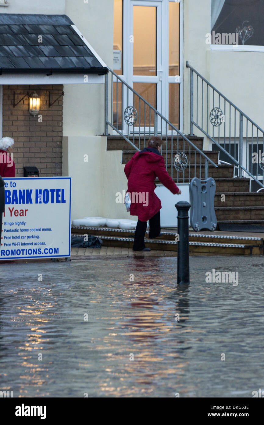 Residents from a seafront hotel try to stay dry from the flooded ...