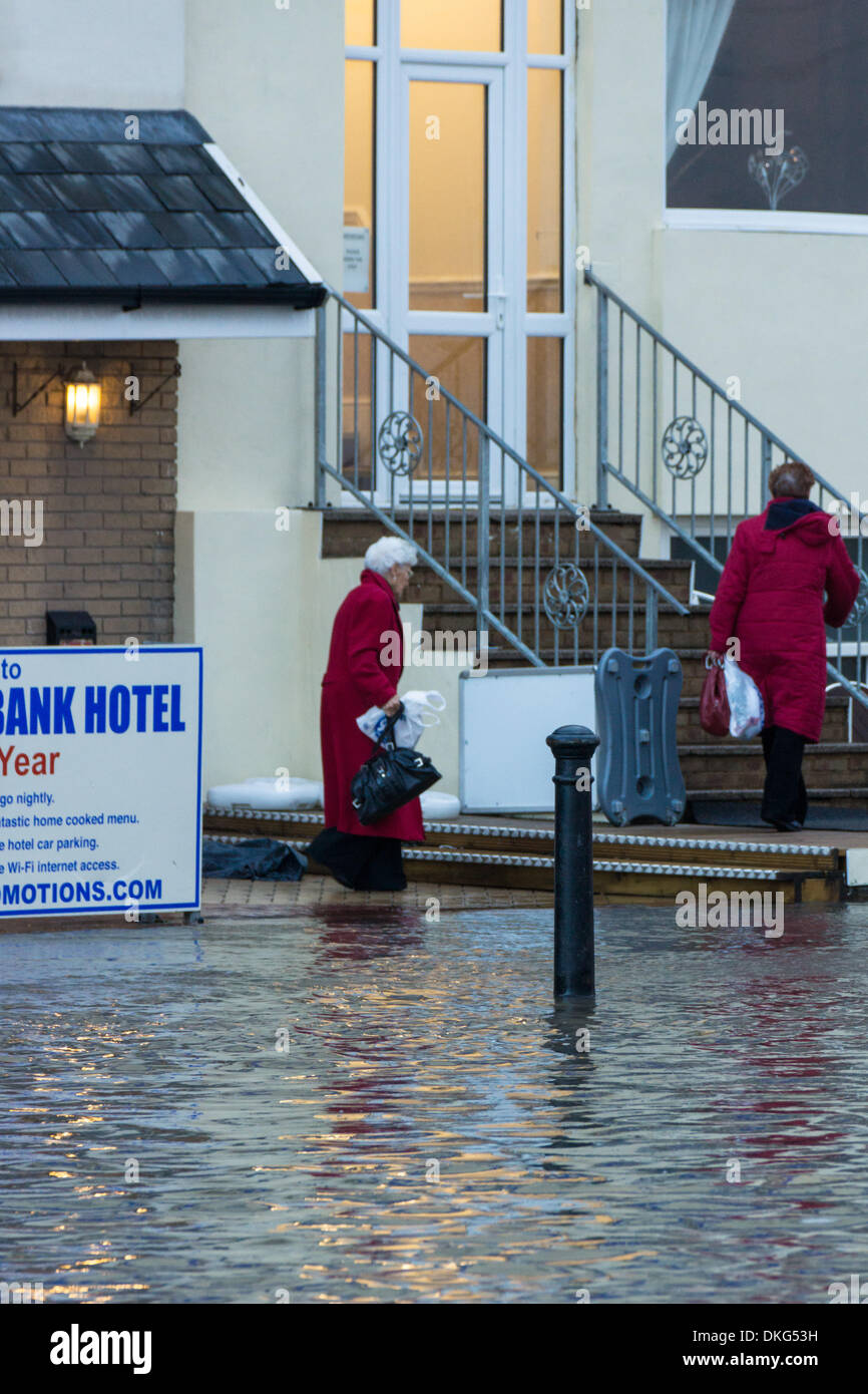 Residents from a seafront hotel try to stay dry from the flooded ...