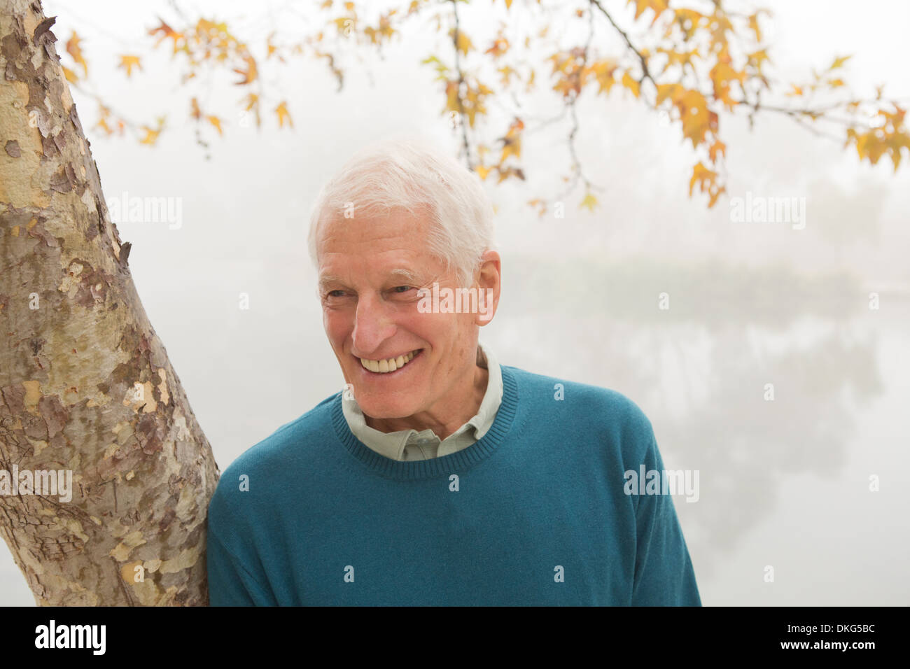 Senior man leaning against tree hi-res stock photography and images - Alamy