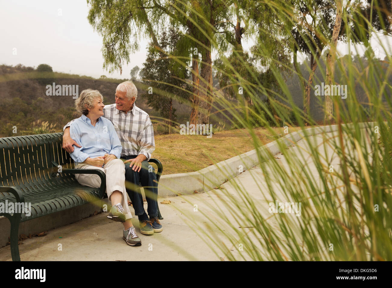 Husband and wife chatting lovingly on park bench Stock Photo - Alamy