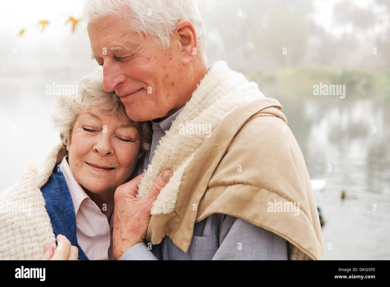 Husband and wife hugging with eyes closed Stock Photo - Alamy