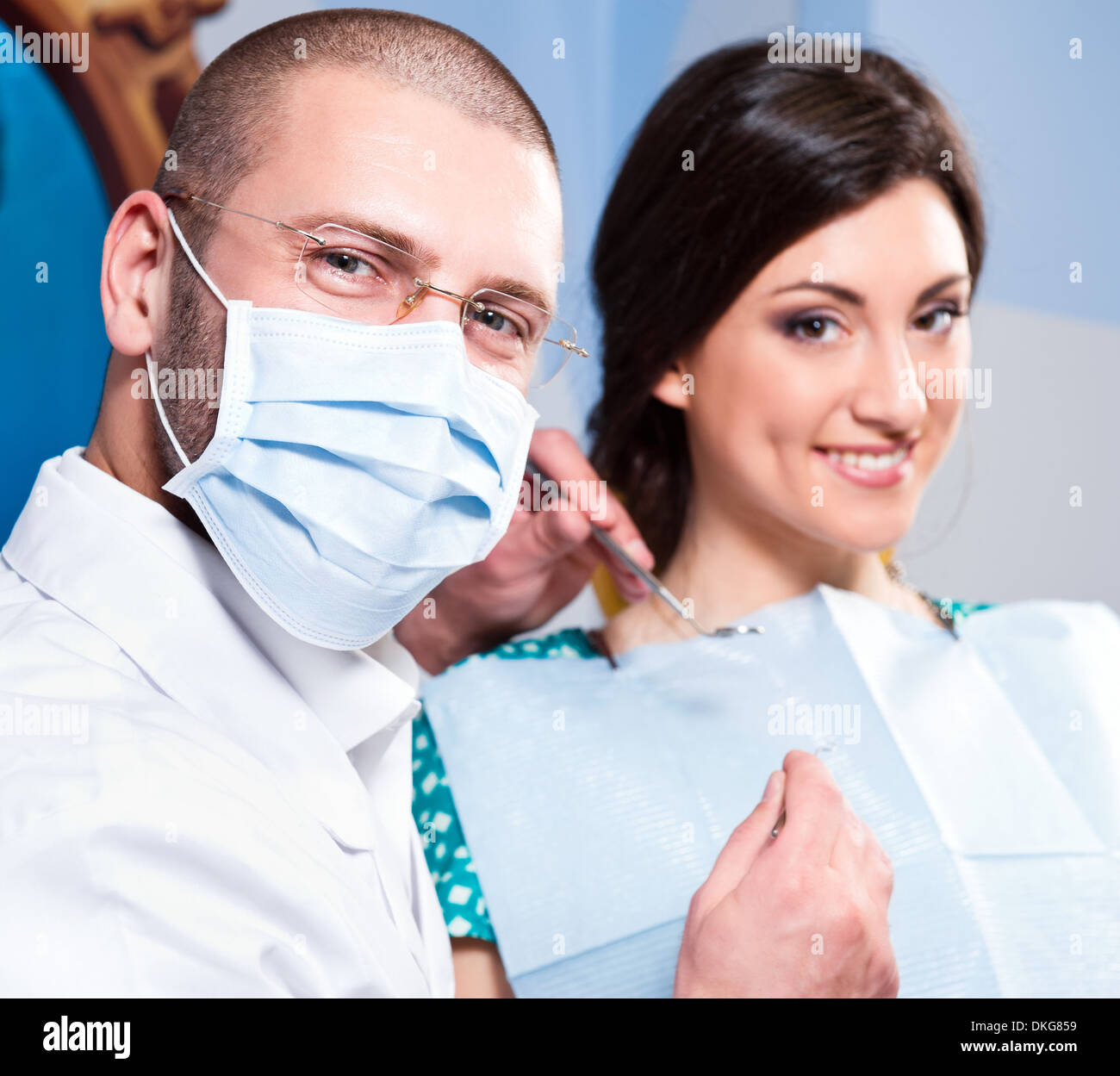Dentist with smiling patient Stock Photo - Alamy