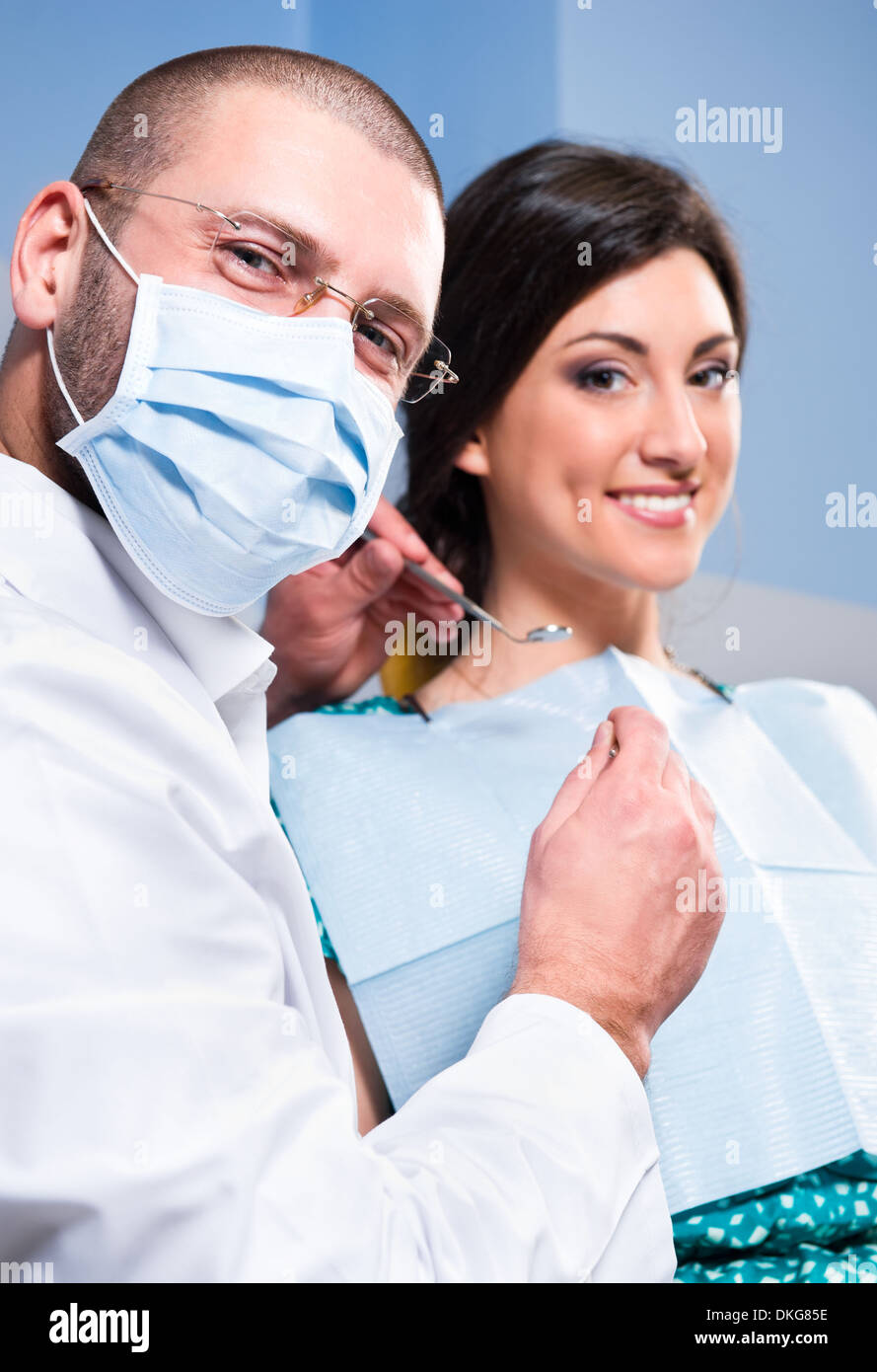 Dentist with smiling patient Stock Photo - Alamy