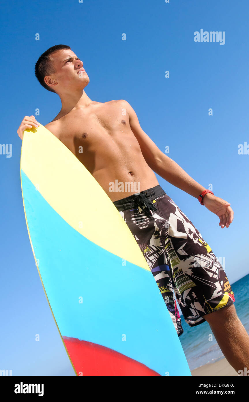 Handsome surfer posing in the beach Stock Photo - Alamy