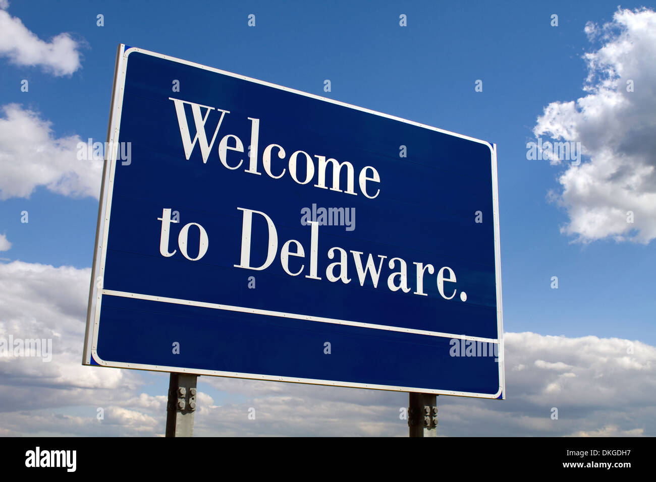 Welcome to Delaware sign on the state live against a cloudy blue sky ...