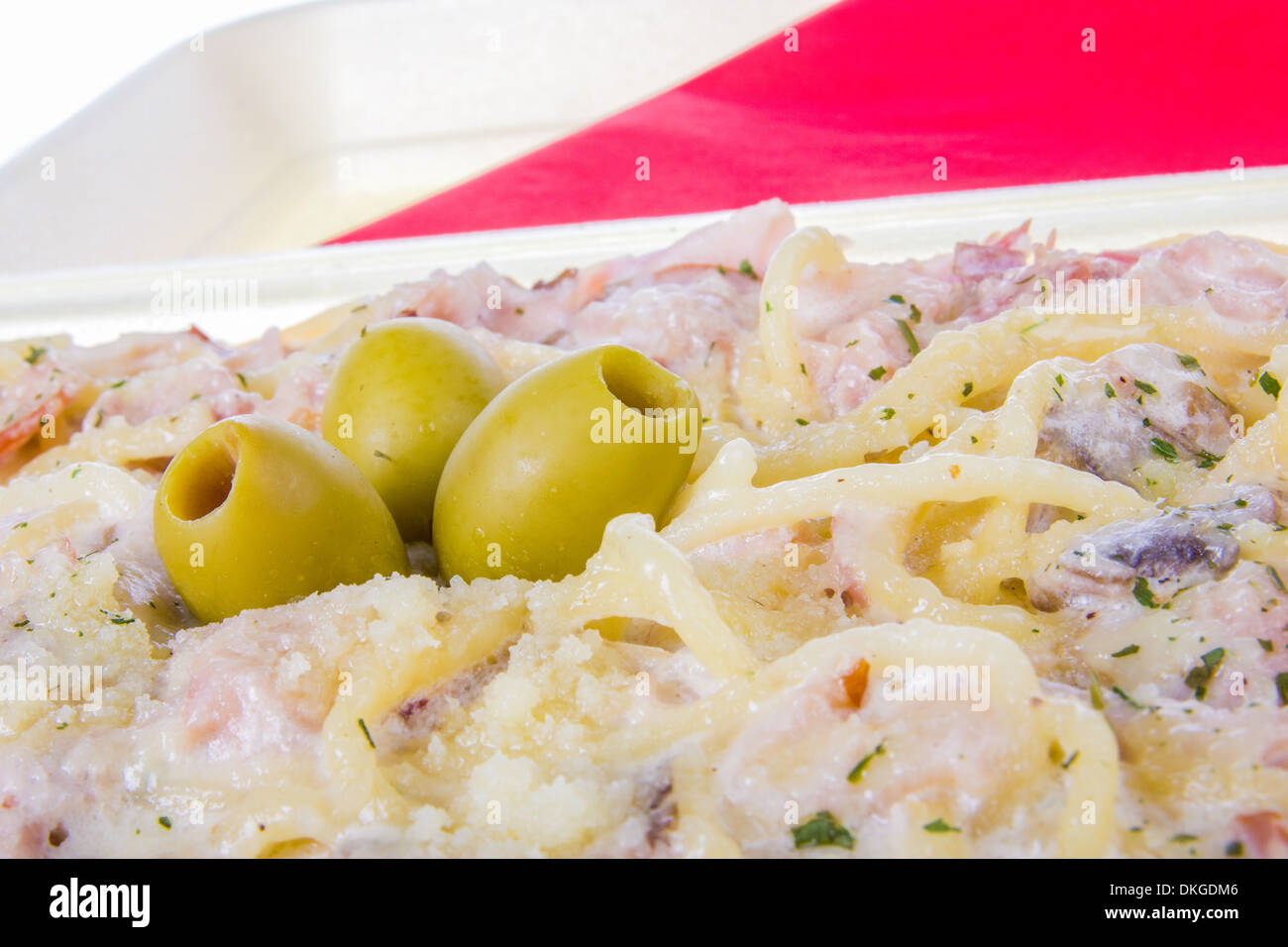 milanese spaghetti in close shot with olives, ham and parmesan Stock ...