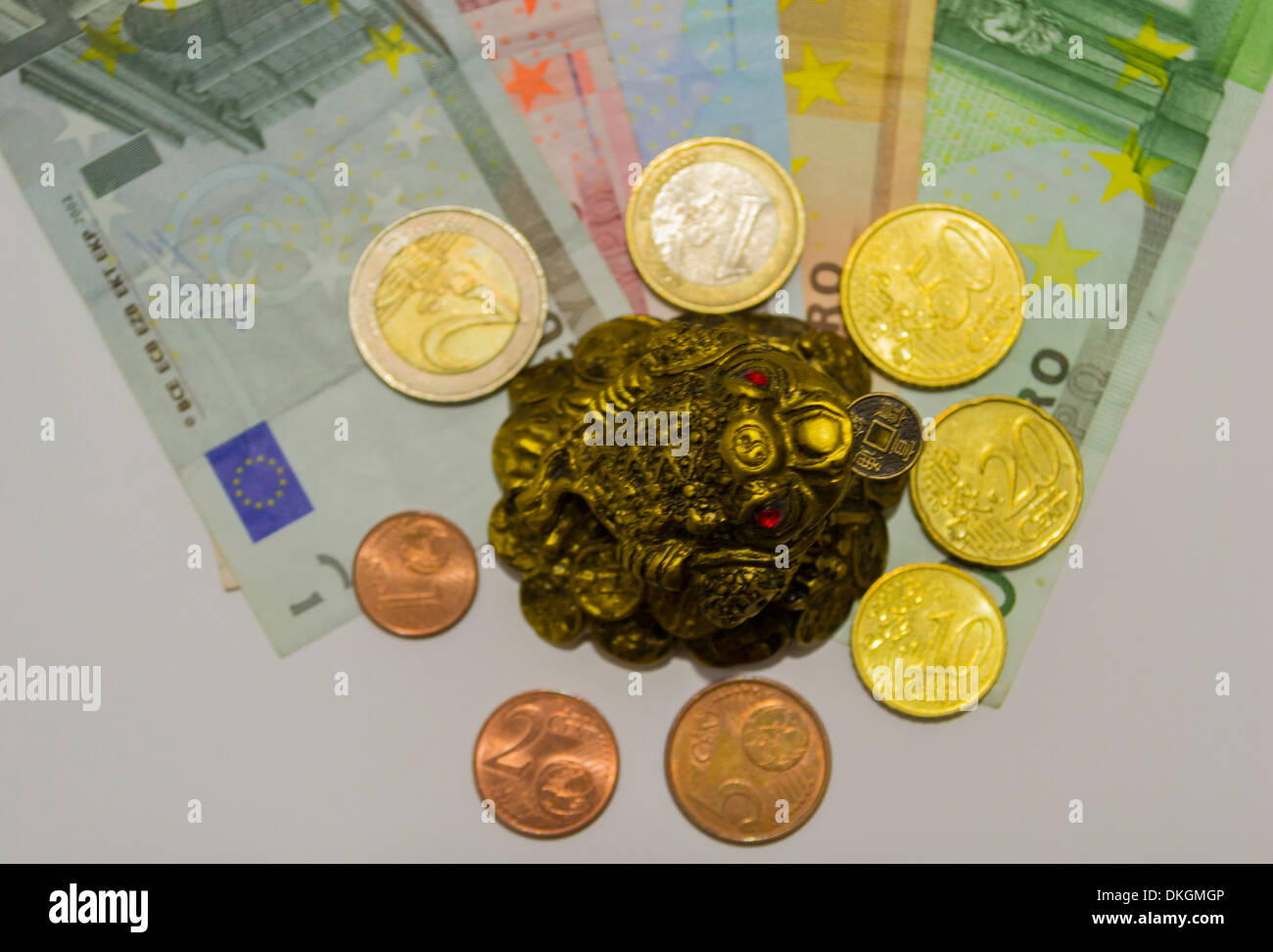 Money toad on Euro coins and banknotes (EUR) - top view Stock Photo - Alamy