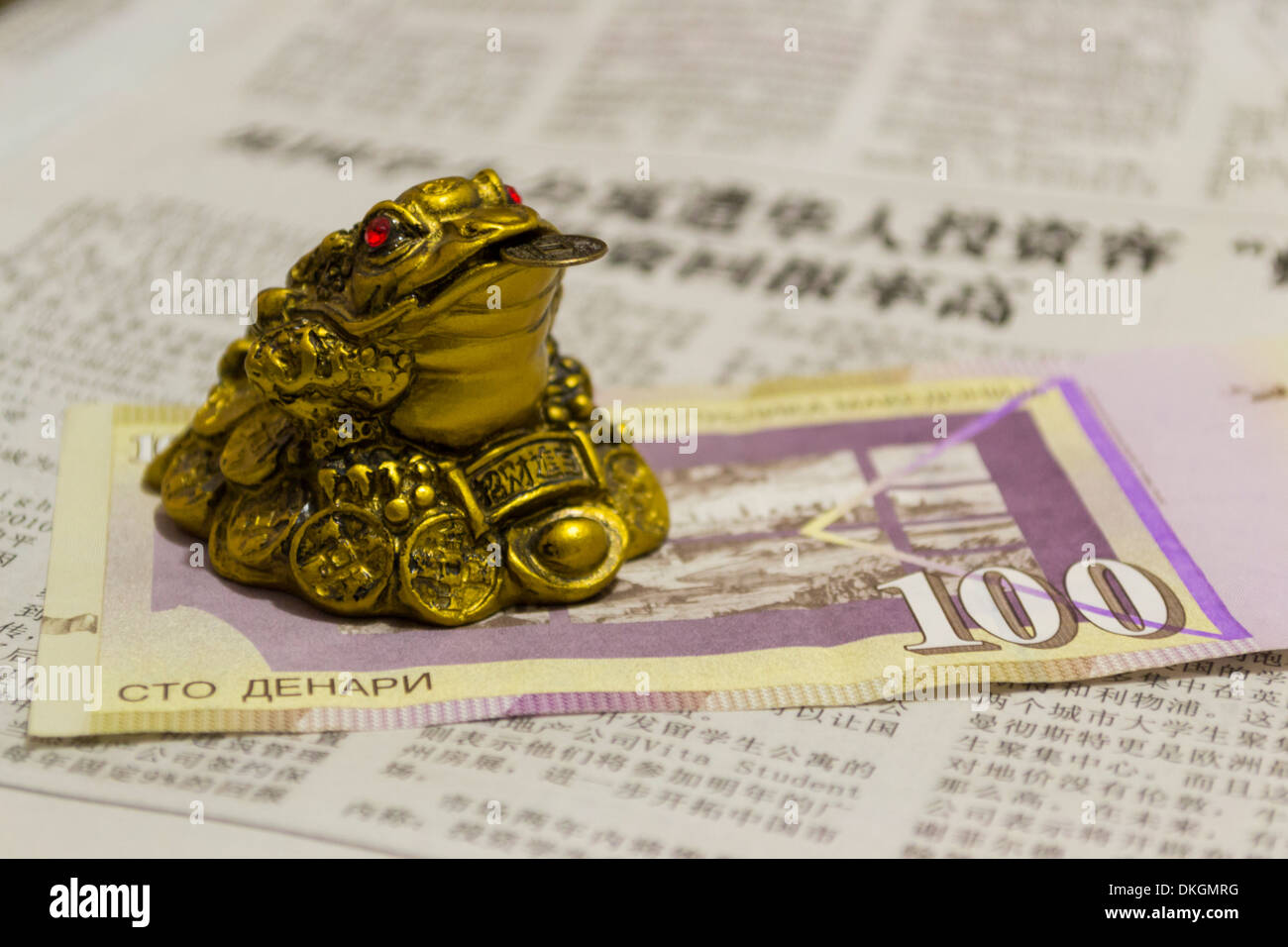 Money toad on Chinese newspaper and 100 Macedonian denars (MKD ...