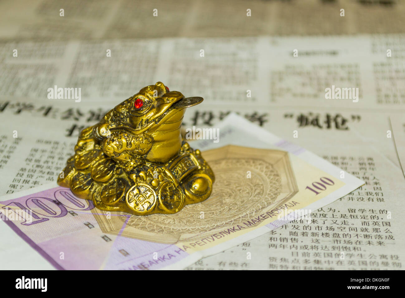 Money toad on Chinese newspaper and 100 Macedonian denars (MKD ...