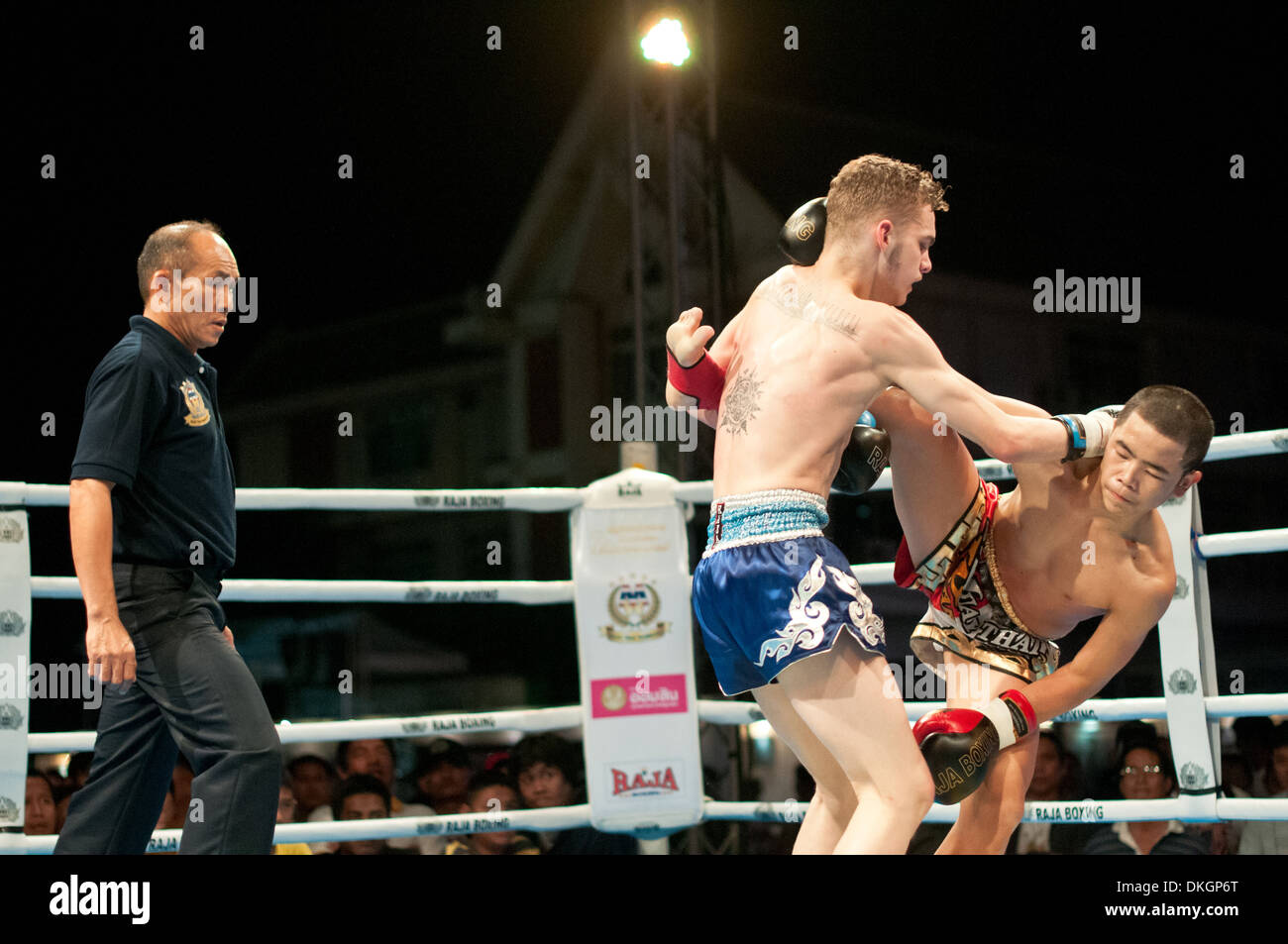 Thai boxer catches a kick from his opponent Stock Photo - Alamy