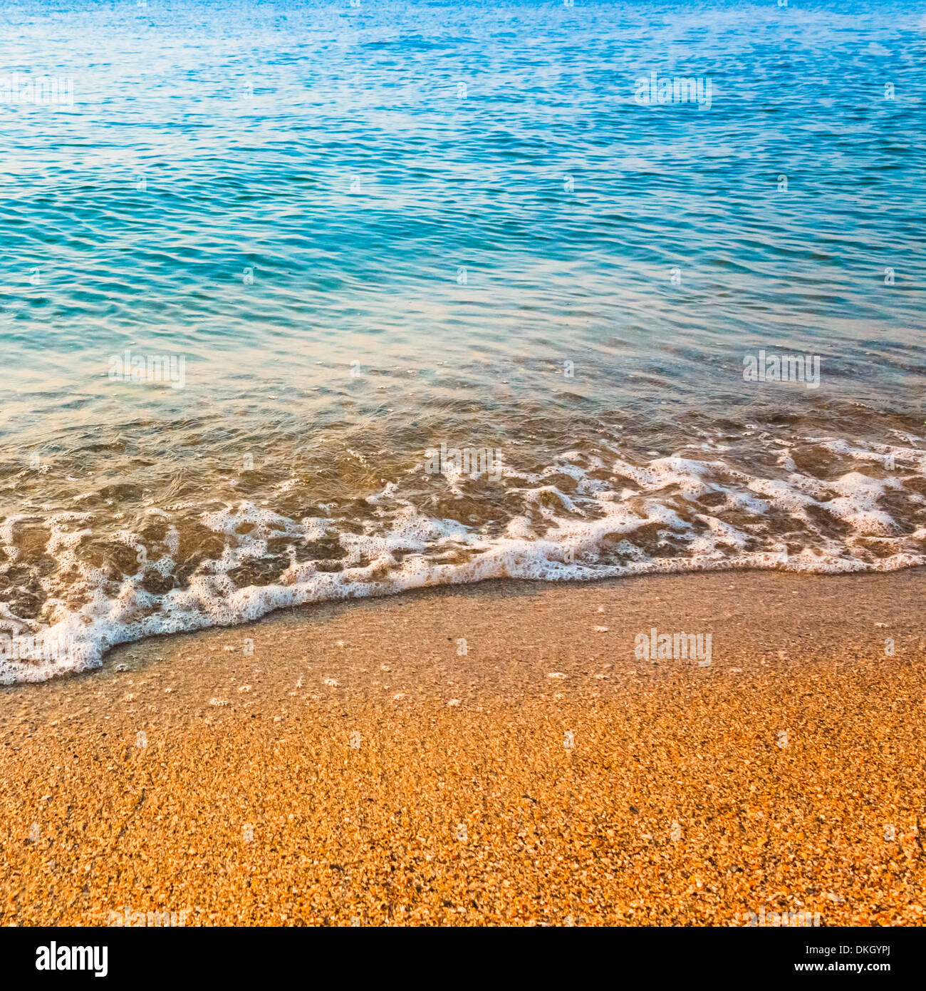 Soft sea ocean waves wash over golden sand background Stock Photo - Alamy