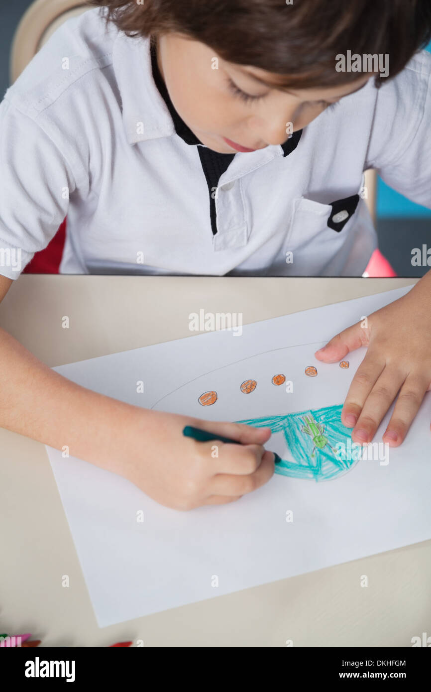 Boy Drawing With Color Pencil In Classroom Stock Photo - Alamy
