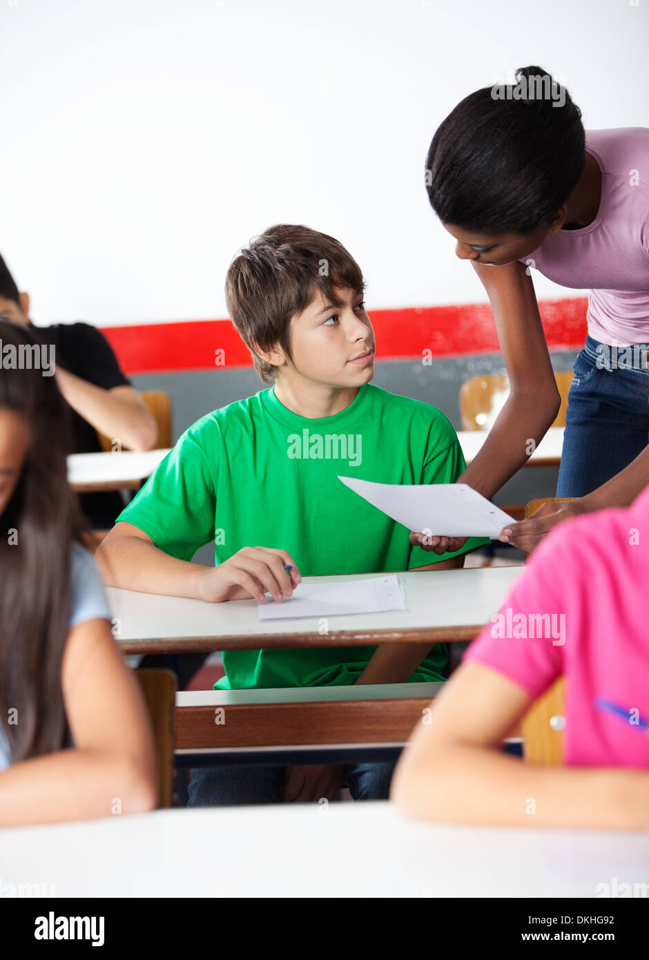 Boy And Teacher Looking At Each Other In Classroom Stock Photo - Alamy