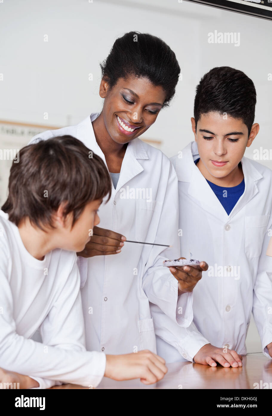 Teacher With Male Students Experimenting At Desk Stock Photo - Alamy