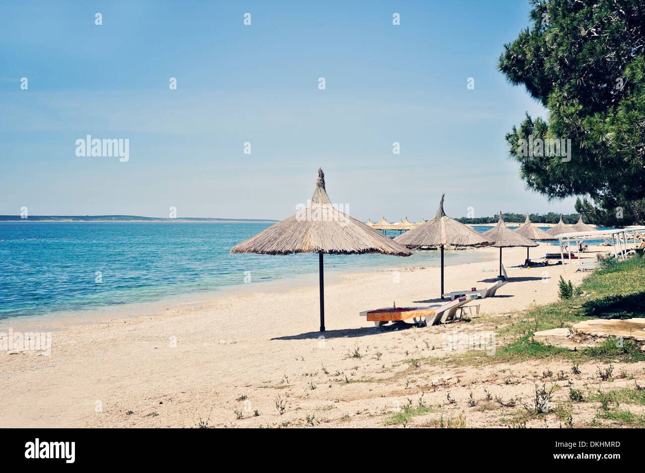 Sunny beach with straw beach umbrella, Island Pag, Croatia, Europe ...