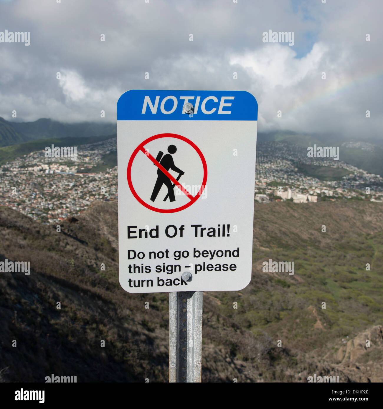 Warning sign for hikers with a city in background viewed from Diamond ...