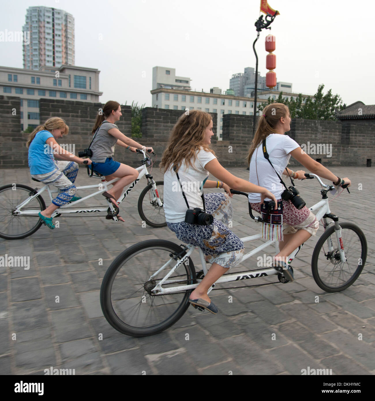 Happy mother with girls riding tandem bicycle at Xian City Wall, Xi'an ...