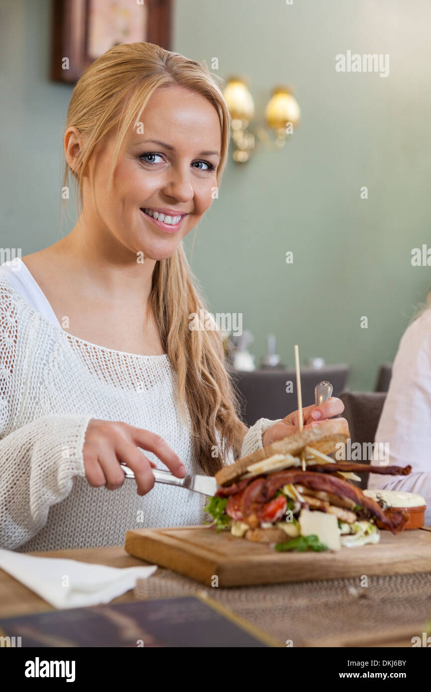 Young Woman Eating Sandwich In Restaurant Stock Photo - Alamy