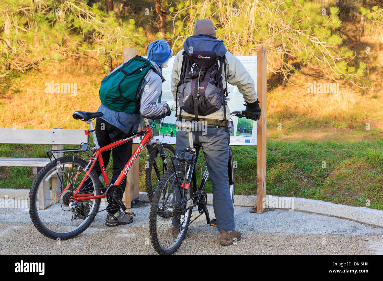 Two cyclists reading new information board about cycle trails in ...