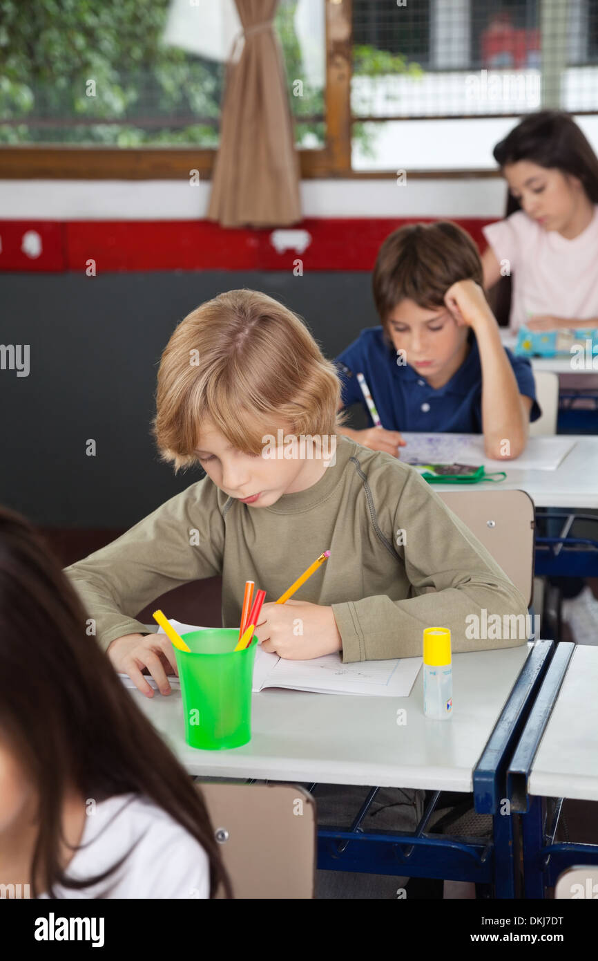 Schoolchildren Studying In Classroom Stock Photo - Alamy