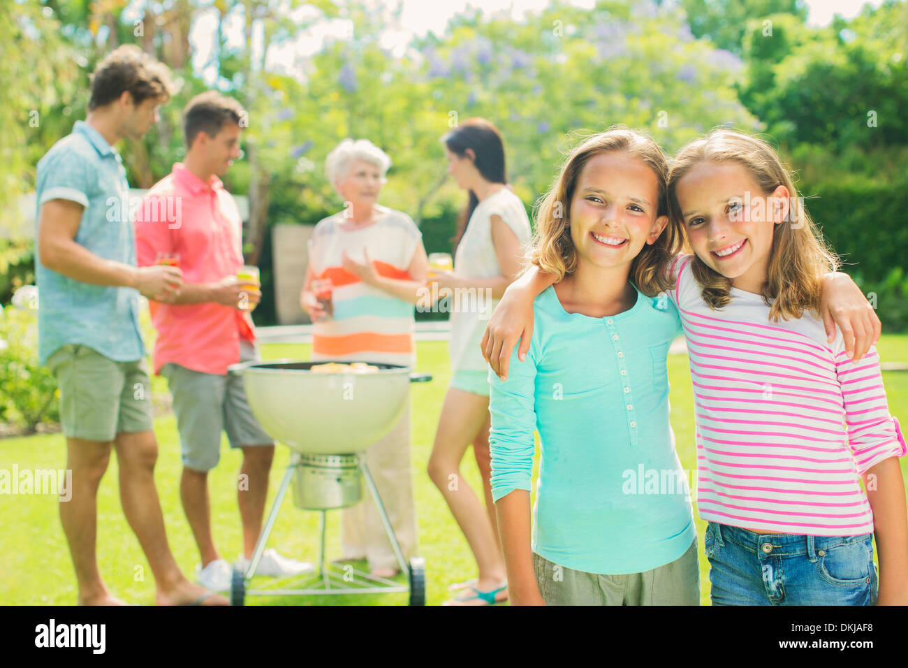 Girls hugging at backyard barbecue Stock Photo - Alamy