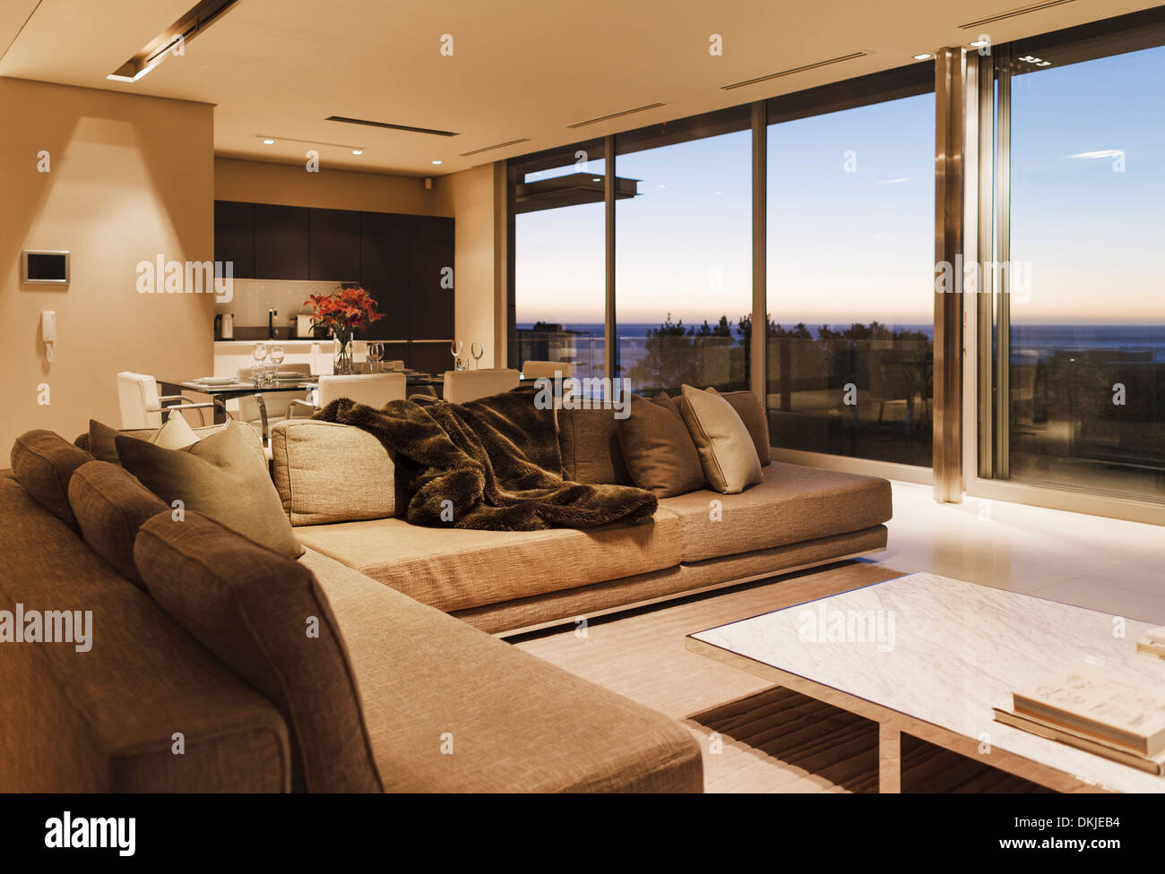 Modern living room overlooking ocean at sunset Stock Photo - Alamy