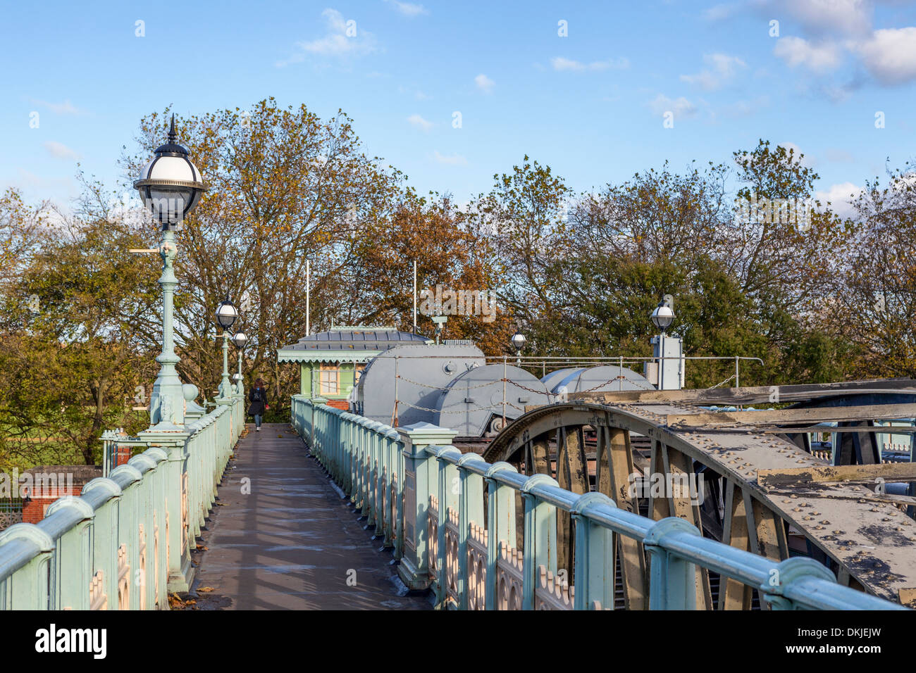Woman crossing the Pedestrian footbridge with decorative lamps and ...