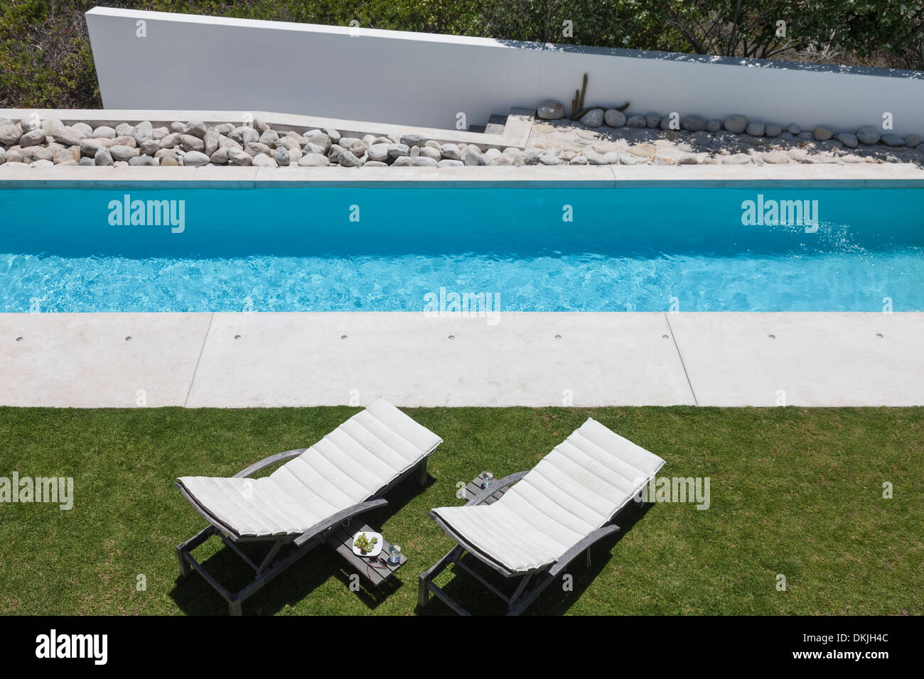 Lounge chairs by modern lap pool Stock Photo - Alamy