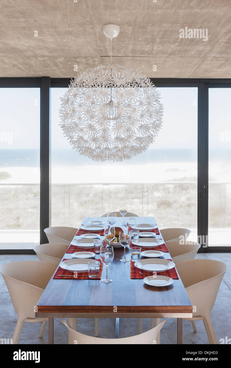 Set table in modern dining room overlooking ocean Stock Photo - Alamy