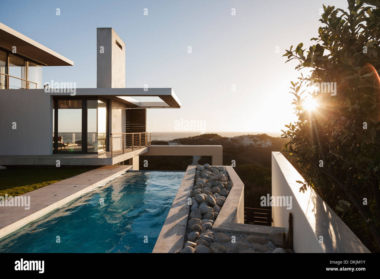 Modern house overlooking beach at sunset Stock Photo - Alamy