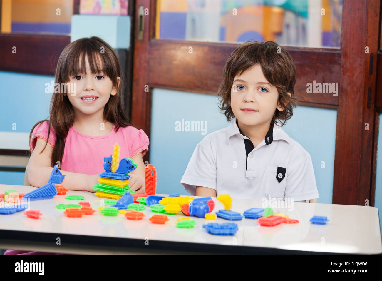 Cute Friends With Construction Blocks In Kindergarten Stock Photo - Alamy
