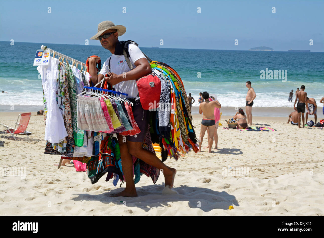 A beach hawker carrying his beach merchandise for sale on Copacabana ...