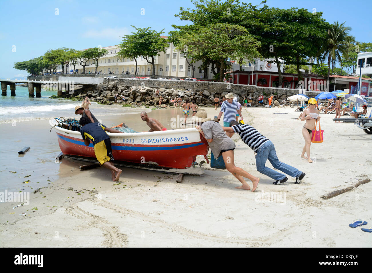 A group of fishermen pushing their boat to sea at Copacabana beach in ...