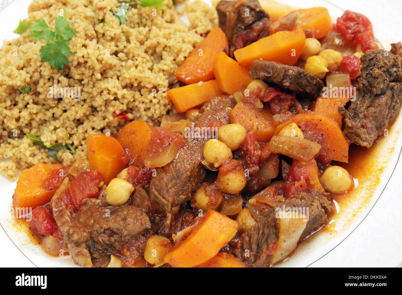 Plate of traditional Moroccan beef tagine with couscous, garnished with ...