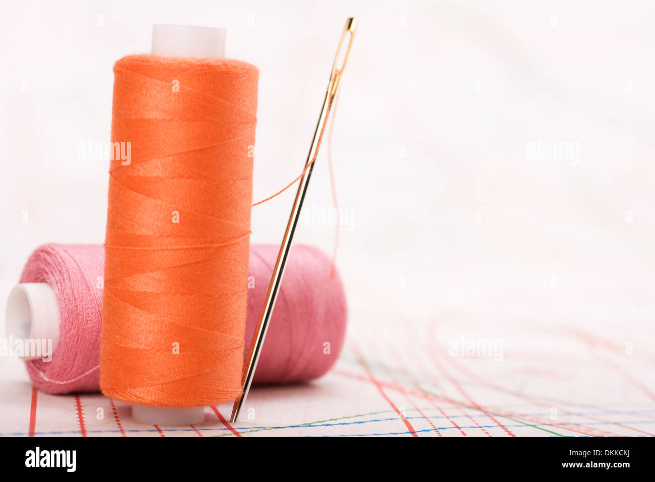 Spool of thread and needle. Sew accessories on blurred background Stock ...