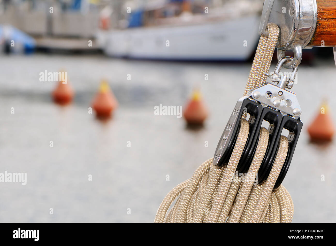Pulley with rope on a sailboat with buoys in background Stock Photo - Alamy