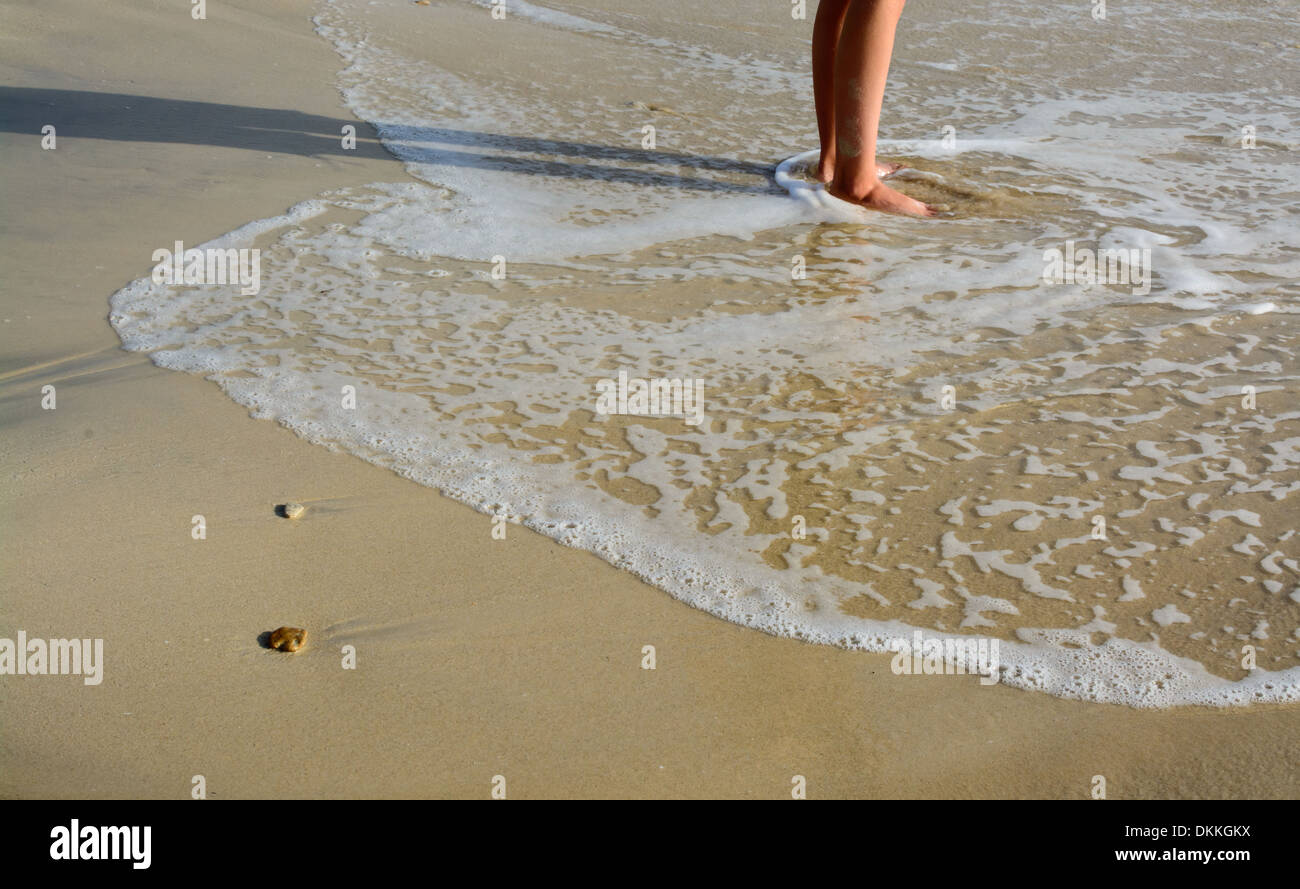Feet on sandy beach with wave and long afternoon shadow Stock Photo - Alamy