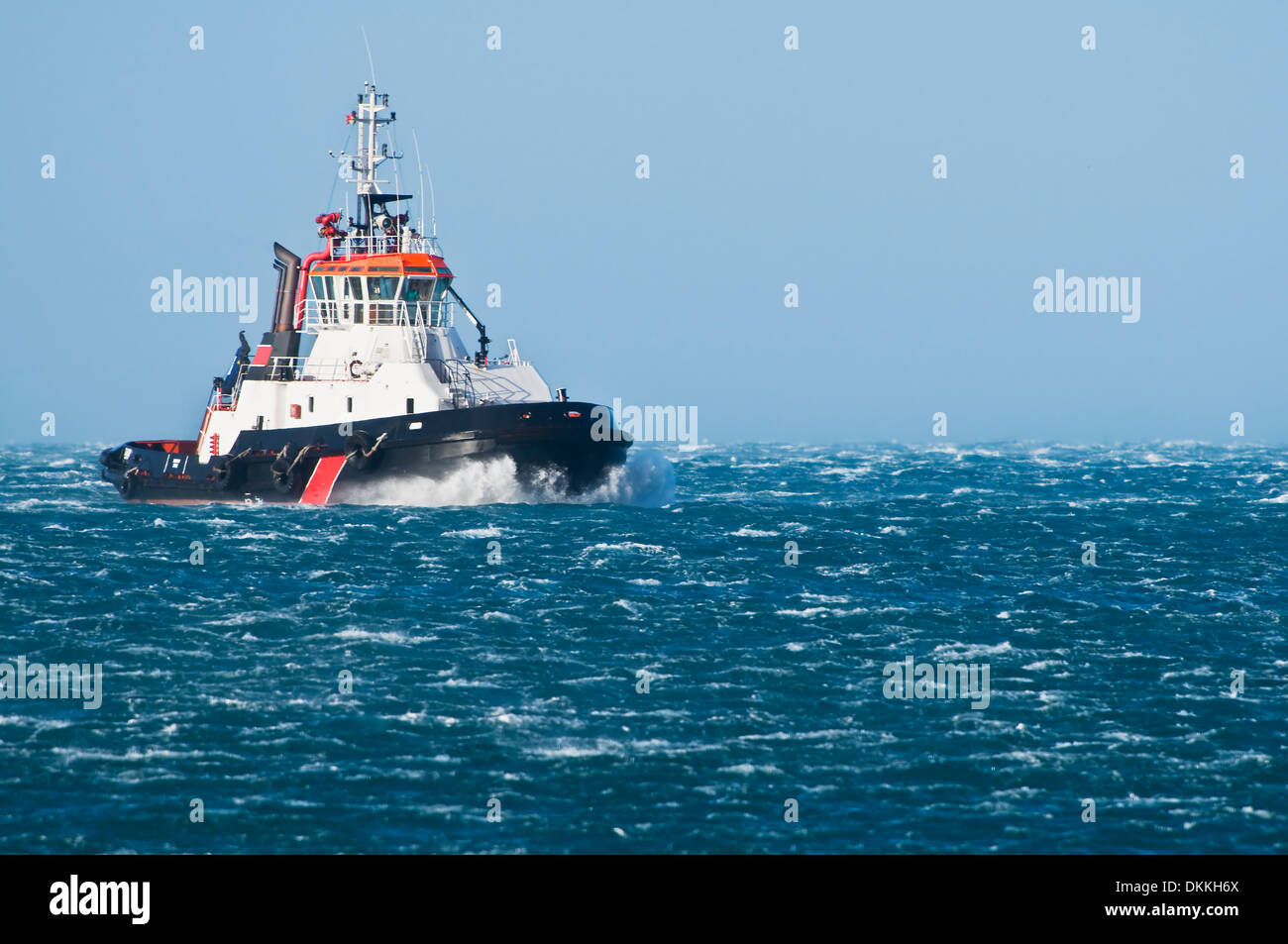 Tug boat navigating in a rough sea Stock Photo - Alamy