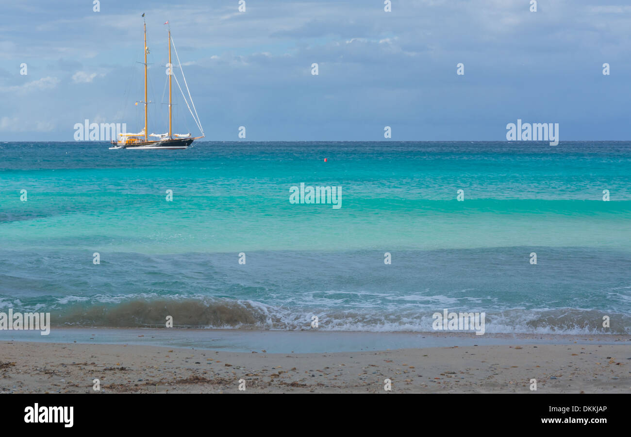 Two masted sailing boat or brig chased by a small gale on turquoise ...