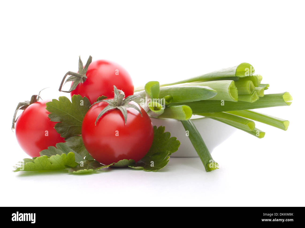 Spring onions and cherry tomato in bowl isolated on white background ...