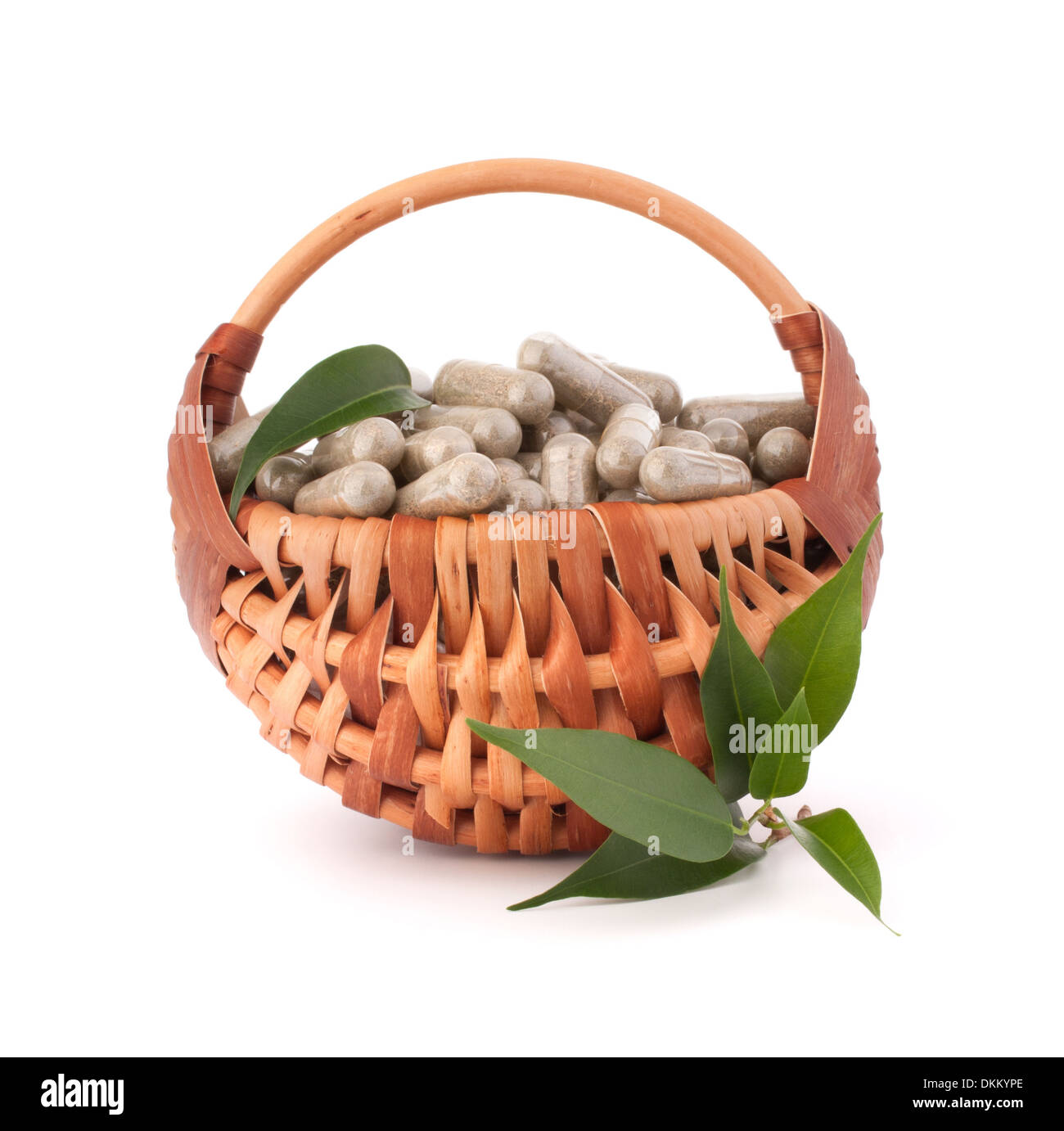 Herbal drug capsules in wicker basket isolated on white background ...