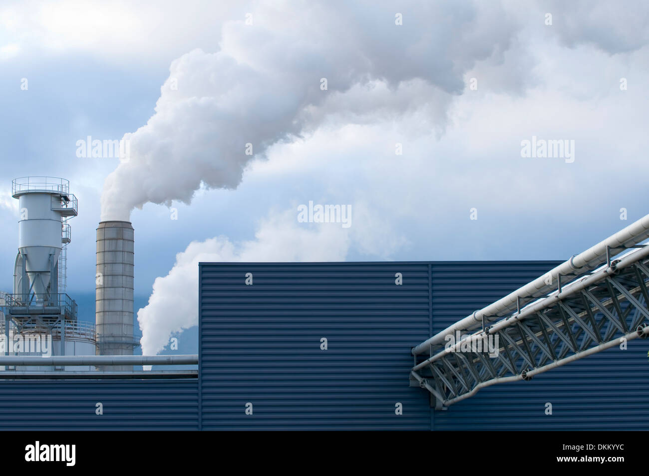 Detail of a modern industrial building with pipes, chimeys and smoke ...