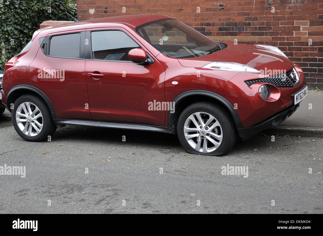 Parked car with front flat tyre on drivers side Stock Photo - Alamy