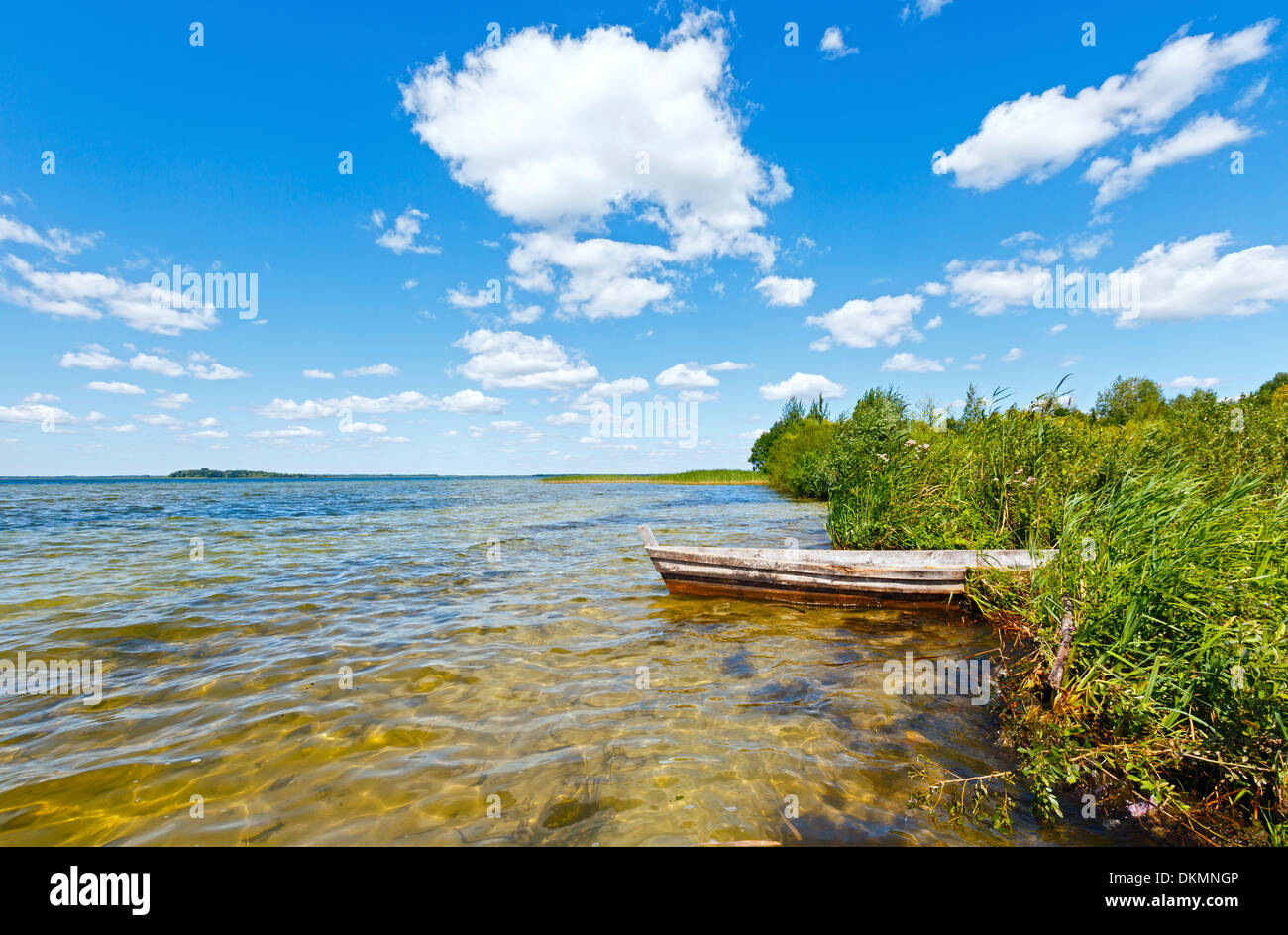 Summer lake view with wooden boat near shore Stock Photo - Alamy