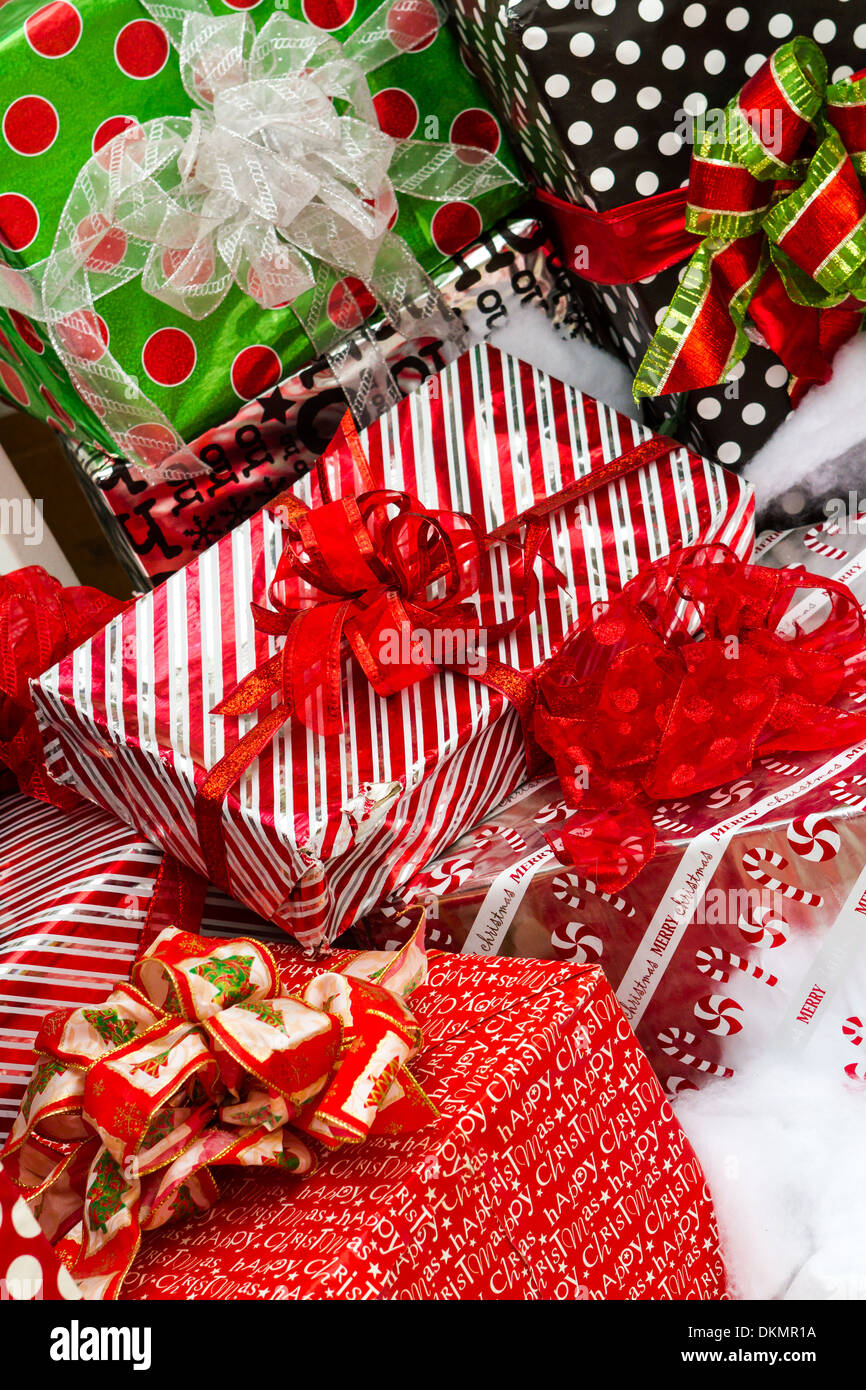 Large presents wrapped in colorful papers with bows in a pile ready for ...