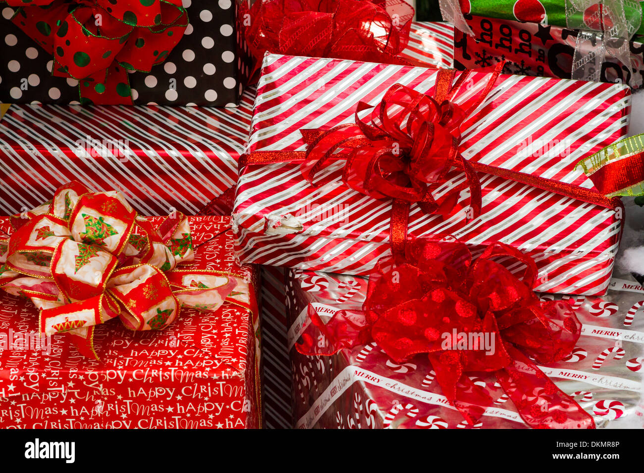 Large presents wrapped in colorful papers with bows in a pile ready for ...