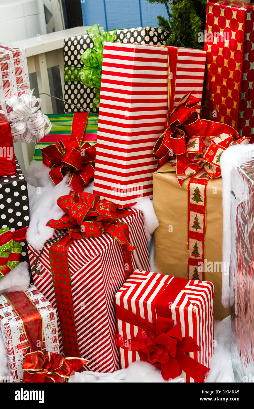 Large presents wrapped in colorful papers with bows in a pile ready for ...